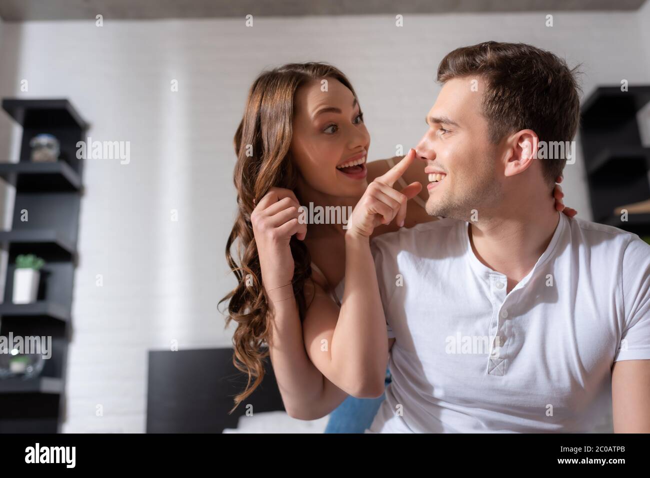 excited girl touching nose of happy boyfriend Stock Photo - Alamy
