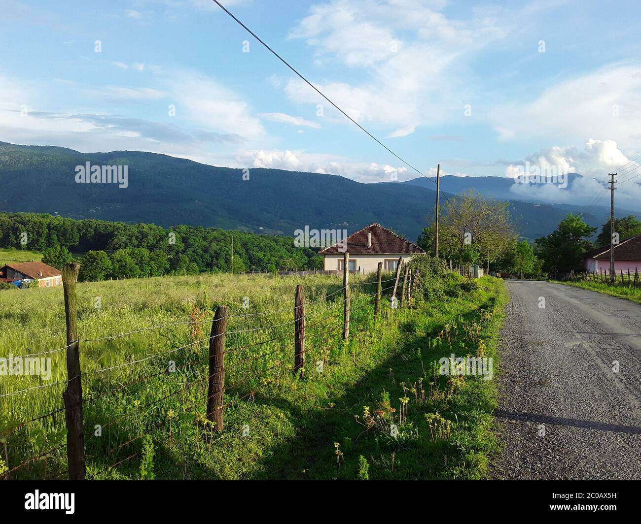 The village house, the footpath, old wooden fences and the green ...