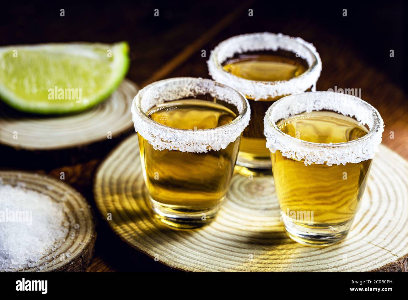 Tequila shot with lemon and sea salt on wooden background, selected ...