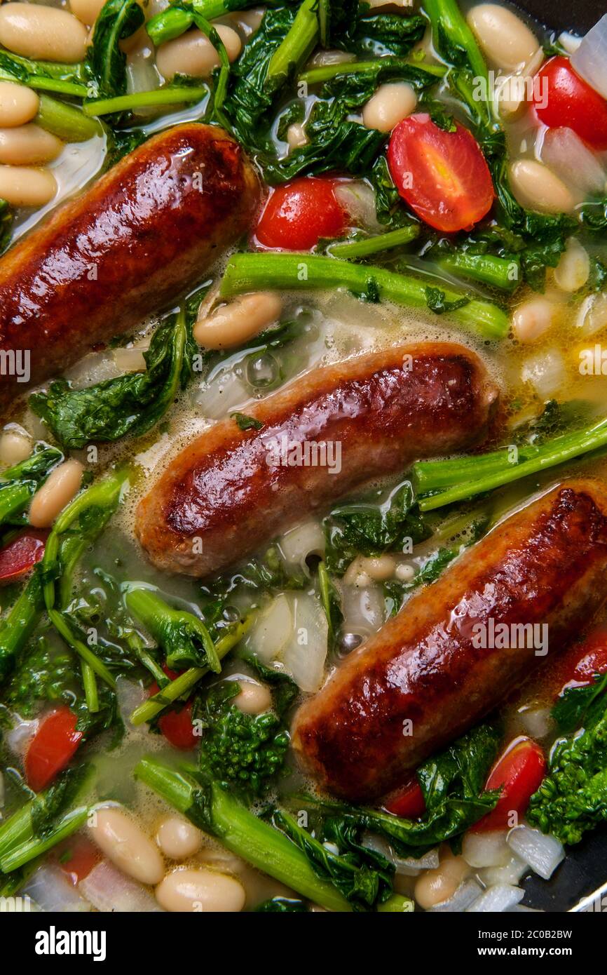 Cooking Italian spicy sausage and broccoli rabe with dramatic lighting ...