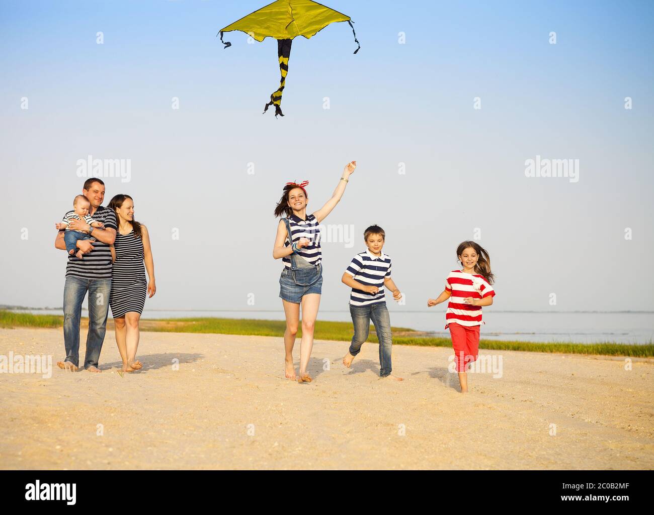 Happy young couple flying kite hi-res stock photography and images - Alamy