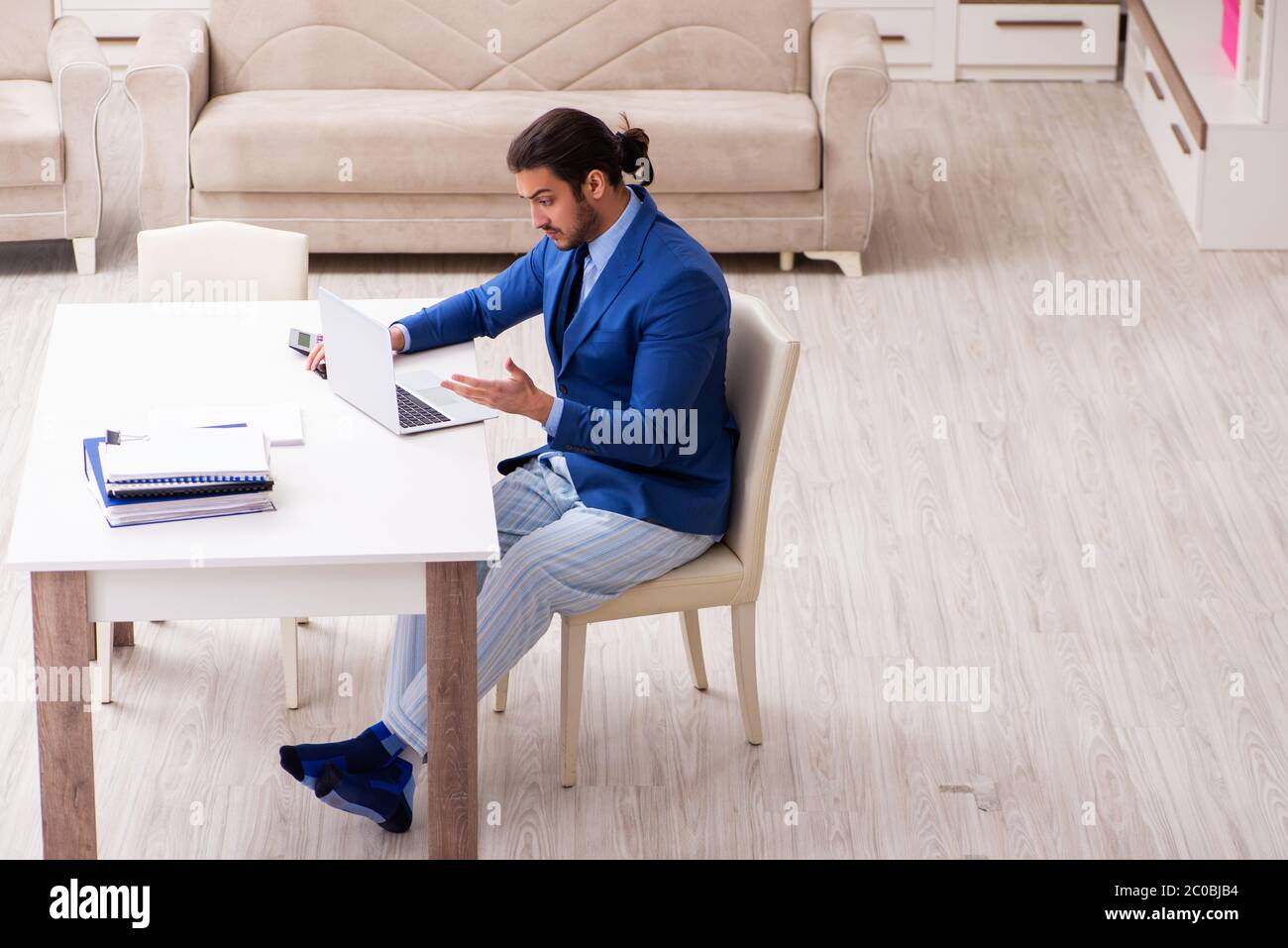 Young employee working from house in self-isolation concept Stock Photo ...