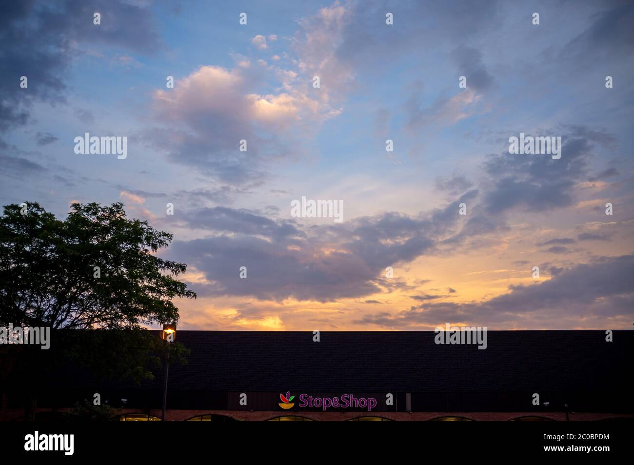 beautiful summer sunset coloring the clouds above grocery store in New ...