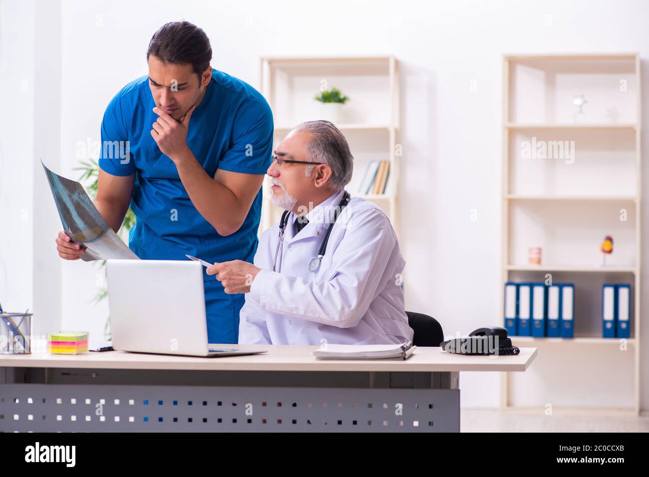 Two male doctors working in the modern clinic Stock Photo - Alamy