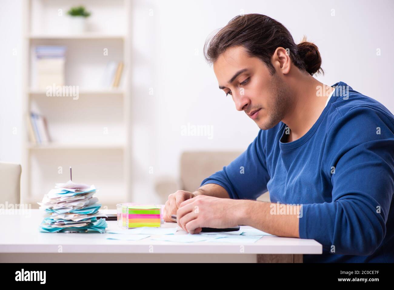 Young man in the budget planning concept Stock Photo - Alamy