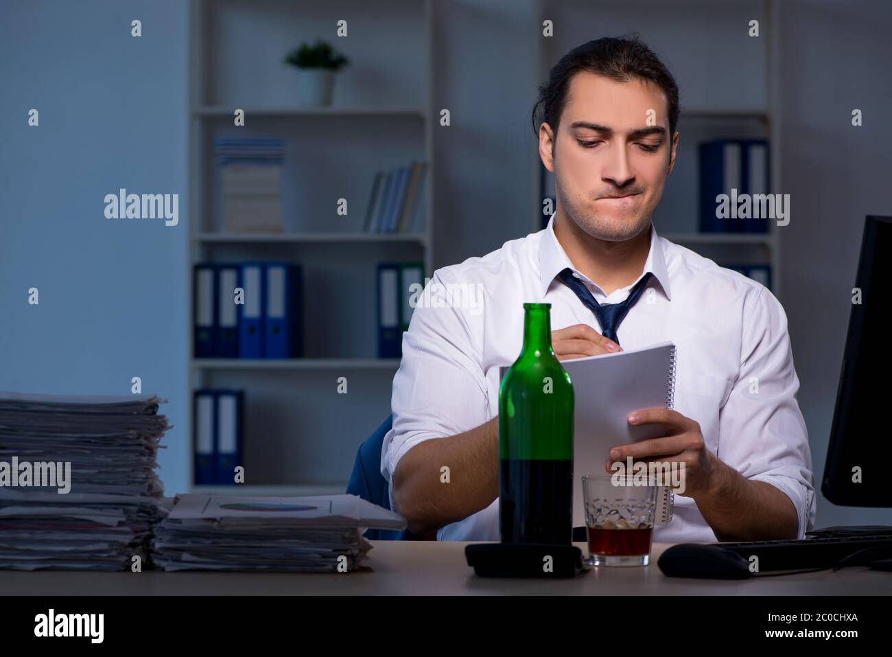 Alcohol addicted businessman working late Stock Photo - Alamy
