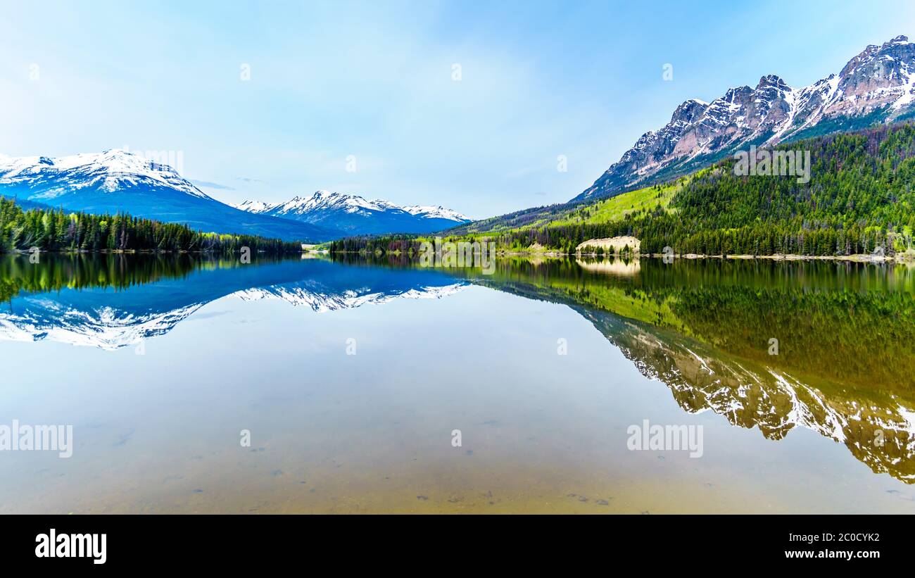 Reflection of the Rocky Mountains range on the smooth water surface of ...