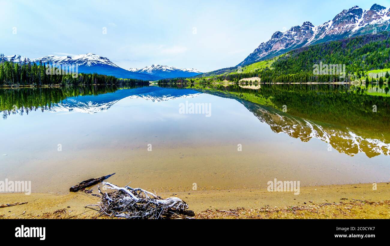 Reflection of the Rocky Mountains range on the smooth water surface of ...
