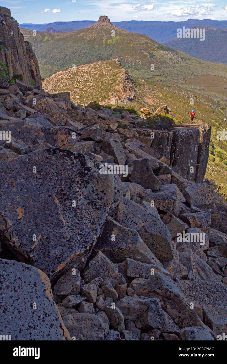 Hiker on the slopes of Mt Ossa, Tasmania's highest peak, looking out to ...