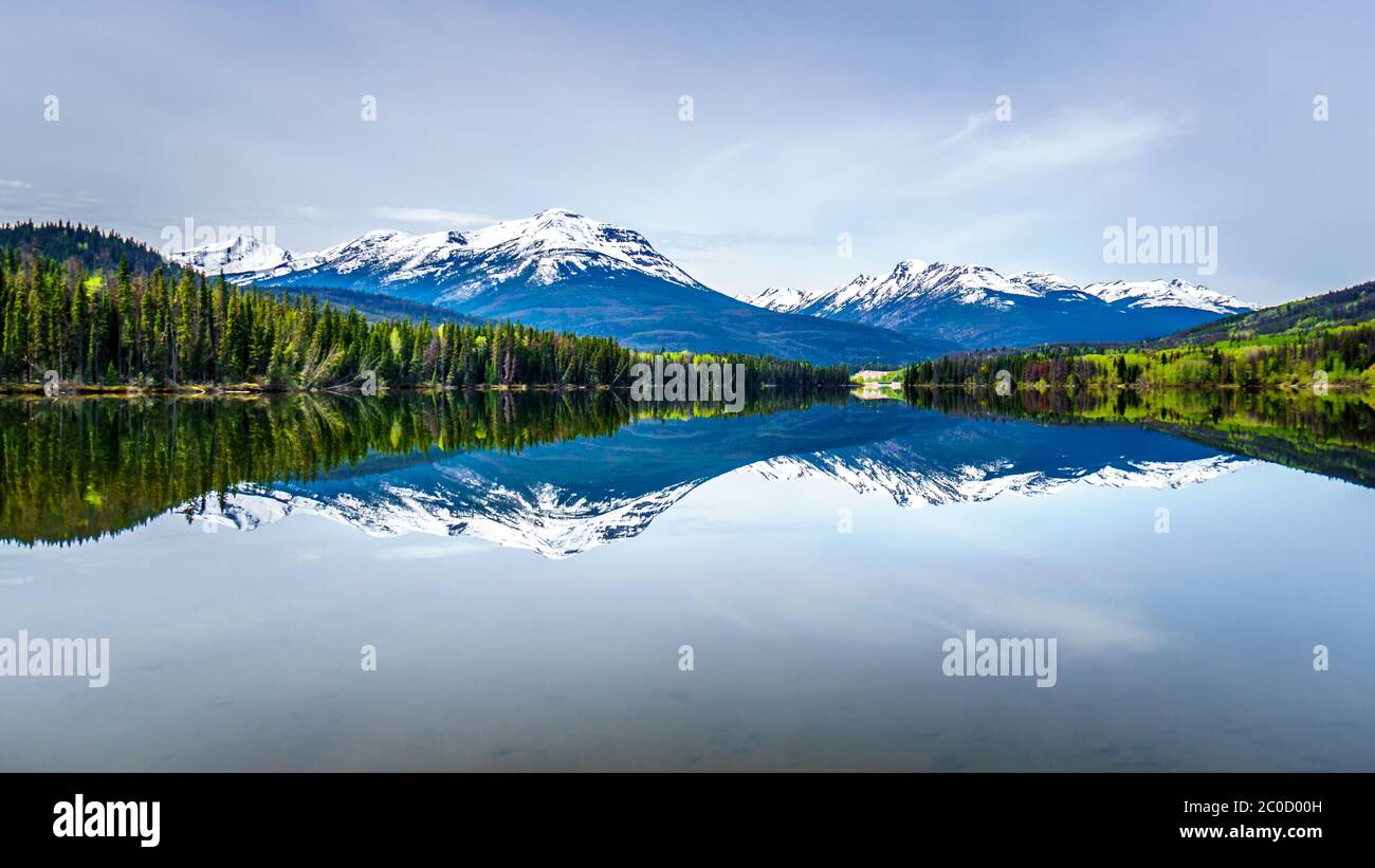 Reflection of the Rocky Mountains range on the smooth water surface of ...