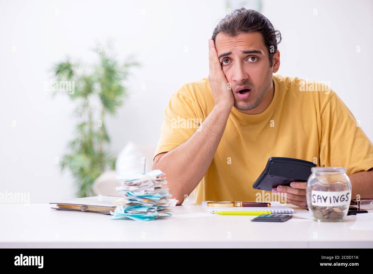 Young man in the budget planning concept Stock Photo - Alamy