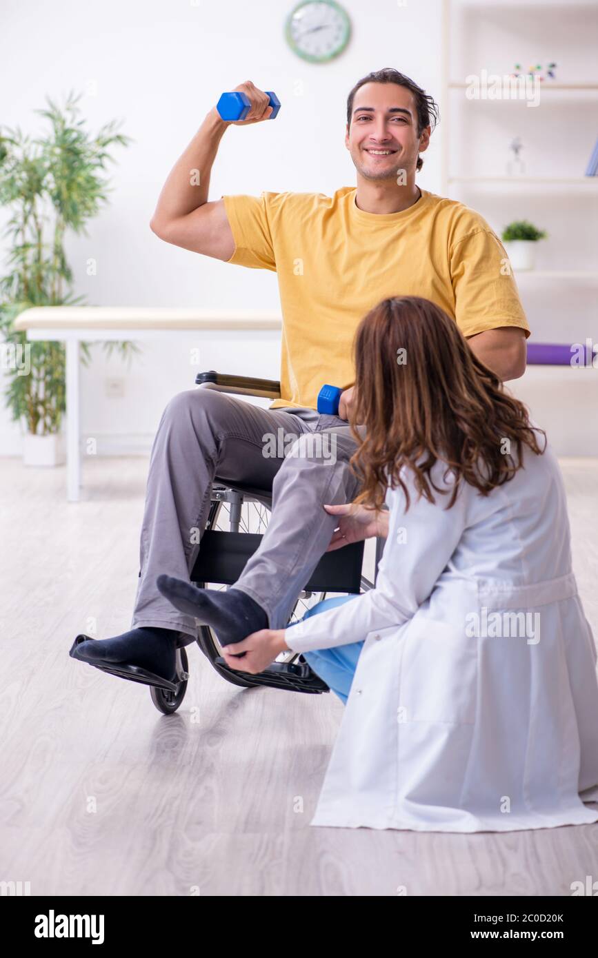 Young male patient in wheel-chair doing physical exercises in hospital ...