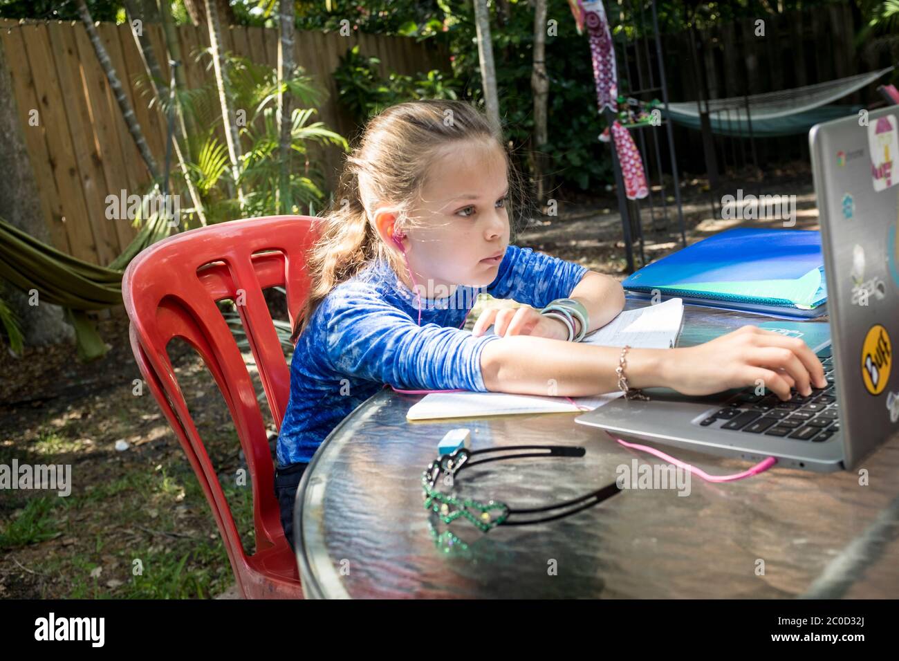 An elementary school age girl works on her laptop computer in the ...