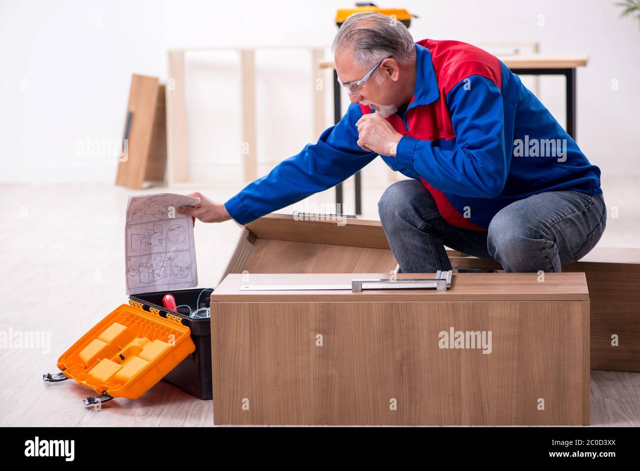 Old carpenter working indoors on furniture Stock Photo - Alamy