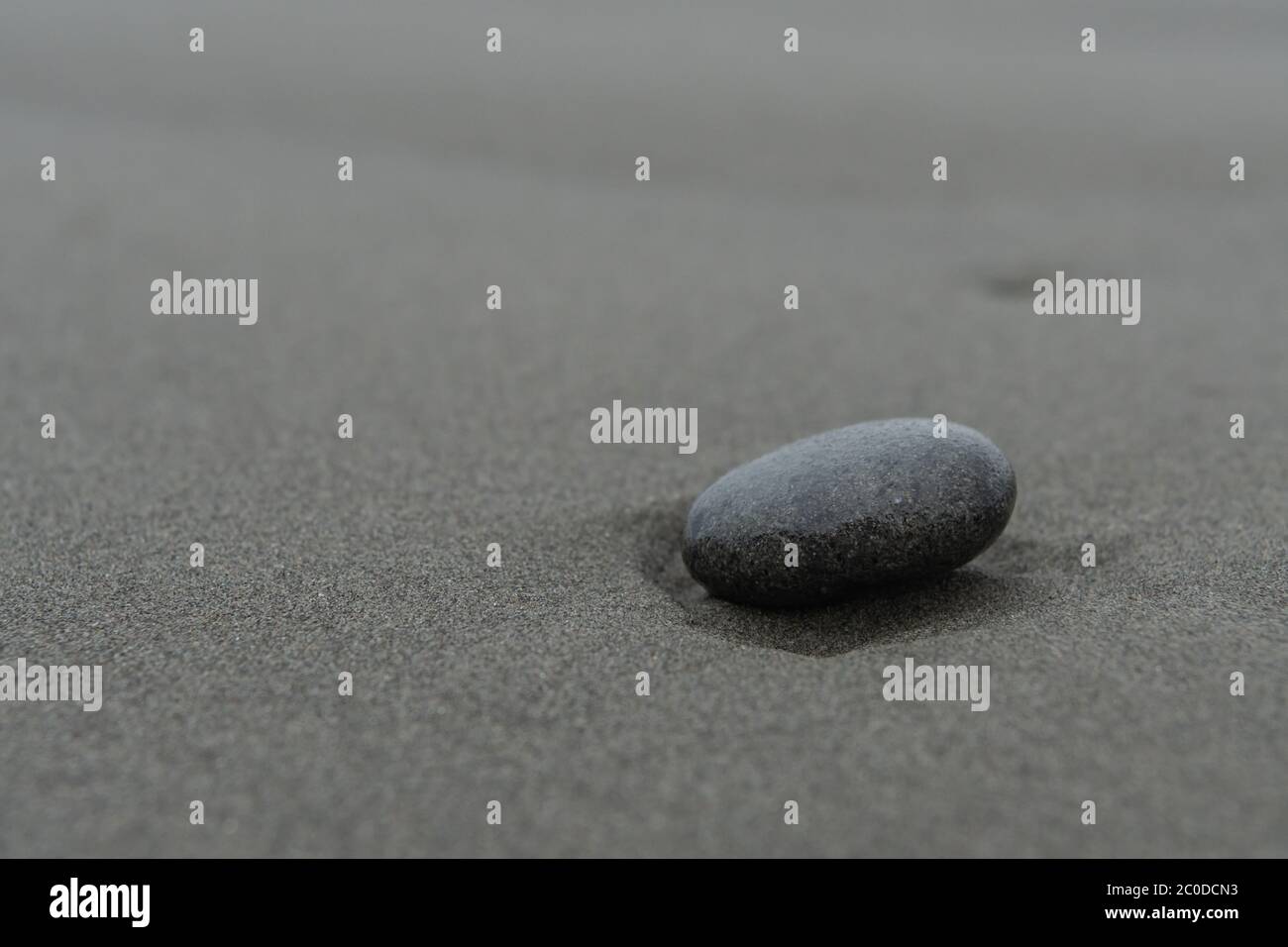 Smooth Rock on Sandy Beach with copy space to left Stock Photo - Alamy