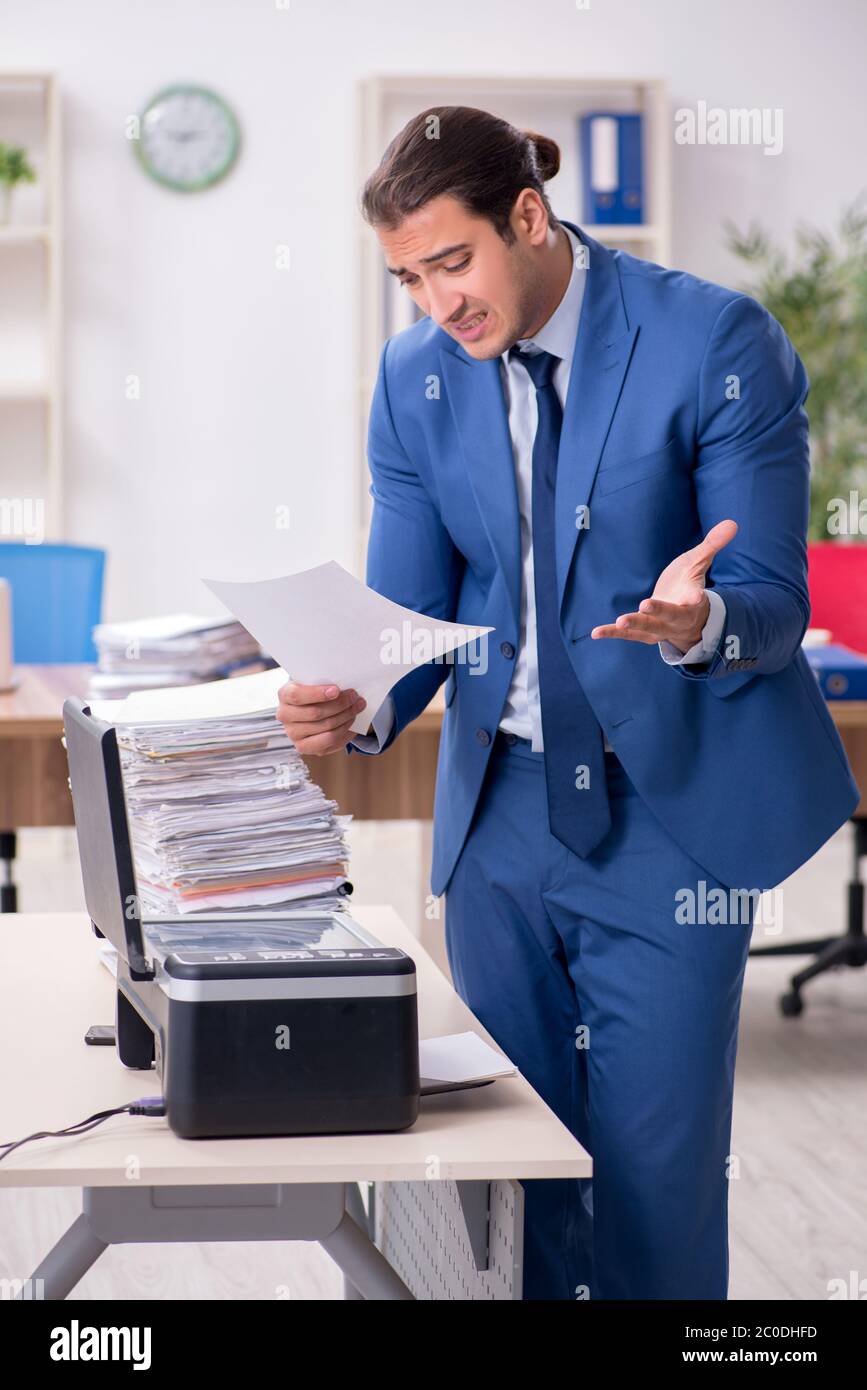 Young employee making copies at copying machine Stock Photo - Alamy
