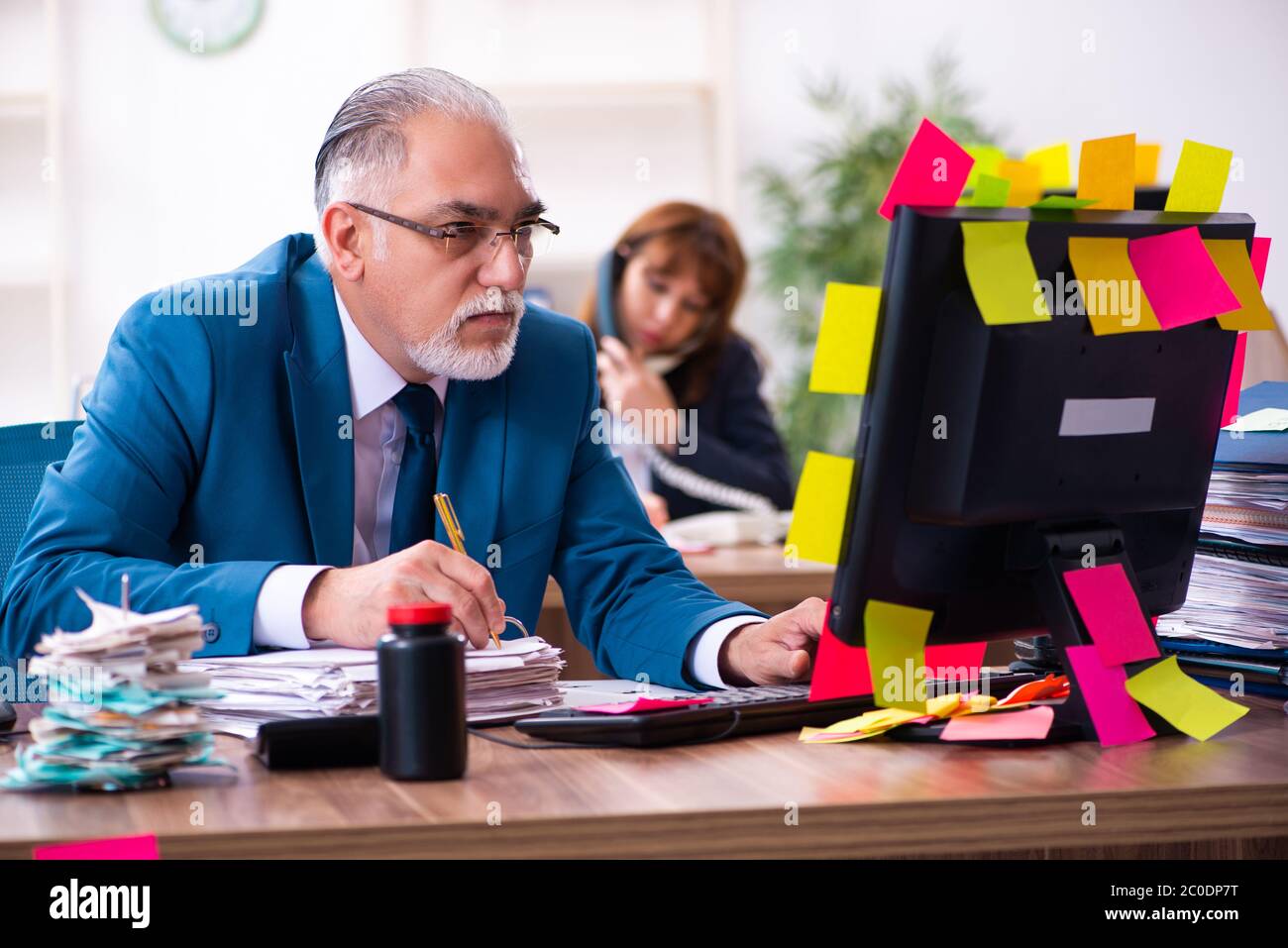 Two employees and excessive work in office Stock Photo - Alamy