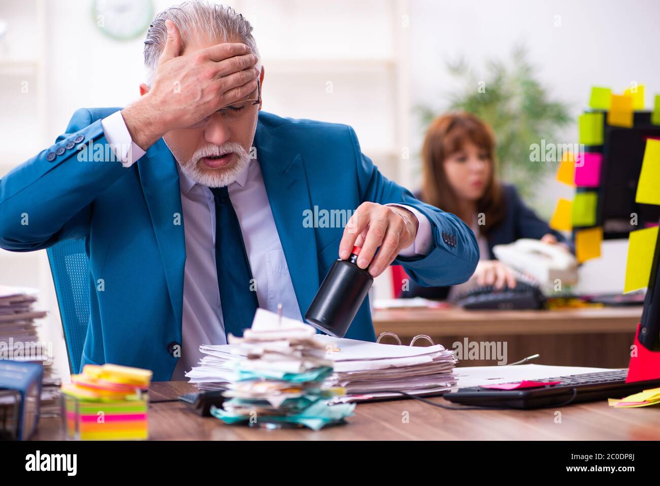Two employees and excessive work in office Stock Photo - Alamy