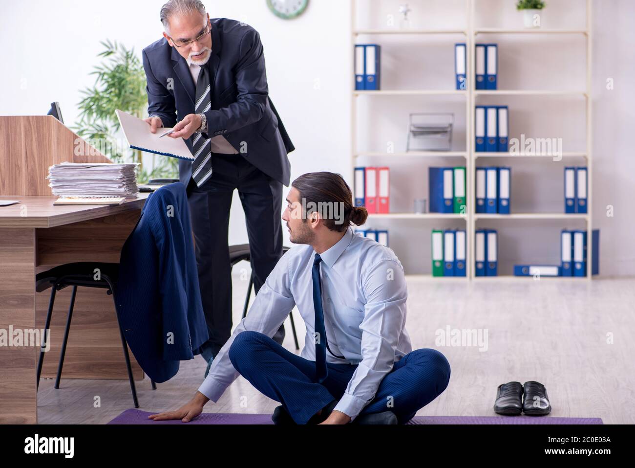 Two employees doing physical exercises at the workplace Stock Photo - Alamy