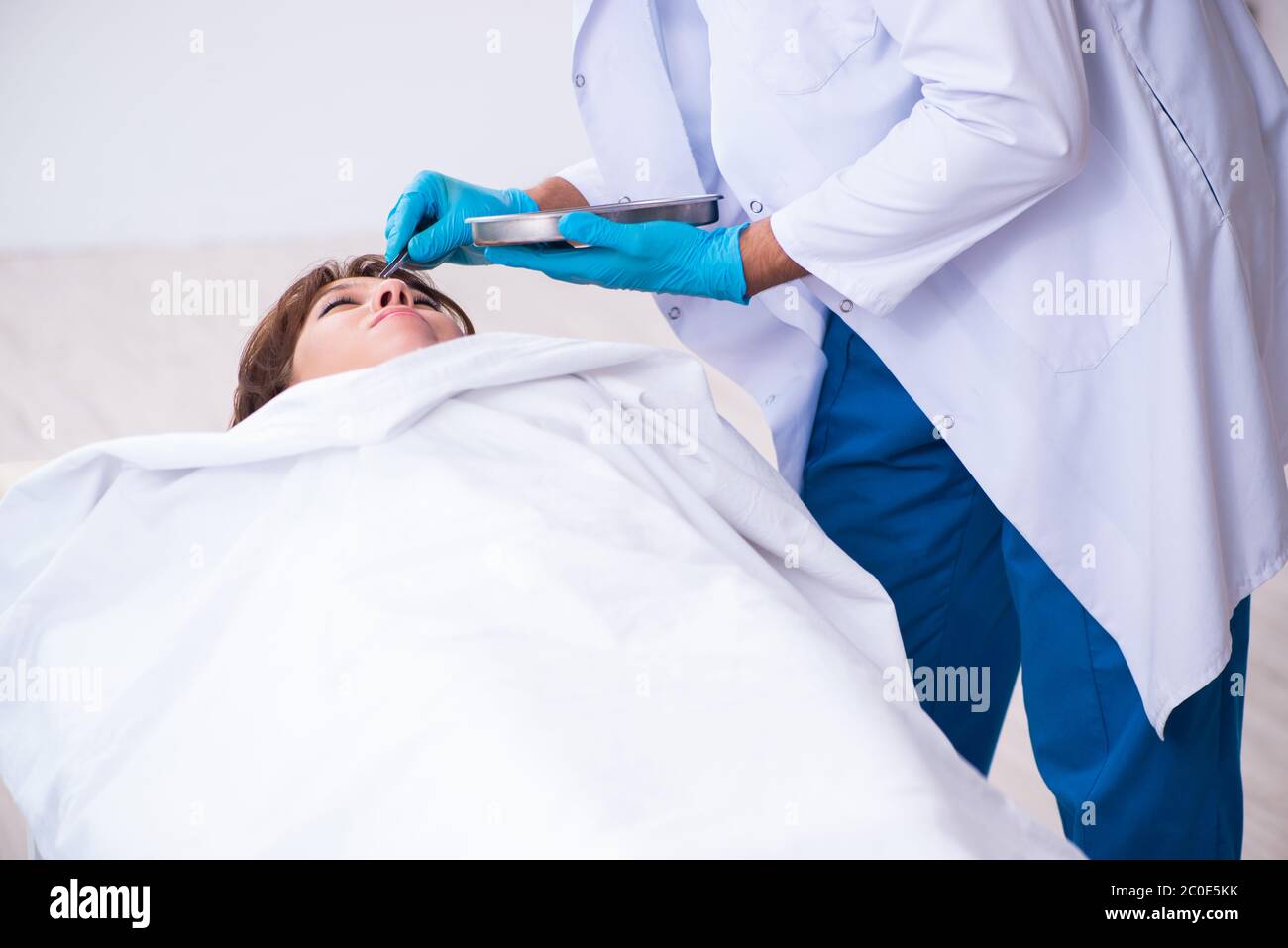 Police coroner examining dead body in morgue Stock Photo - Alamy