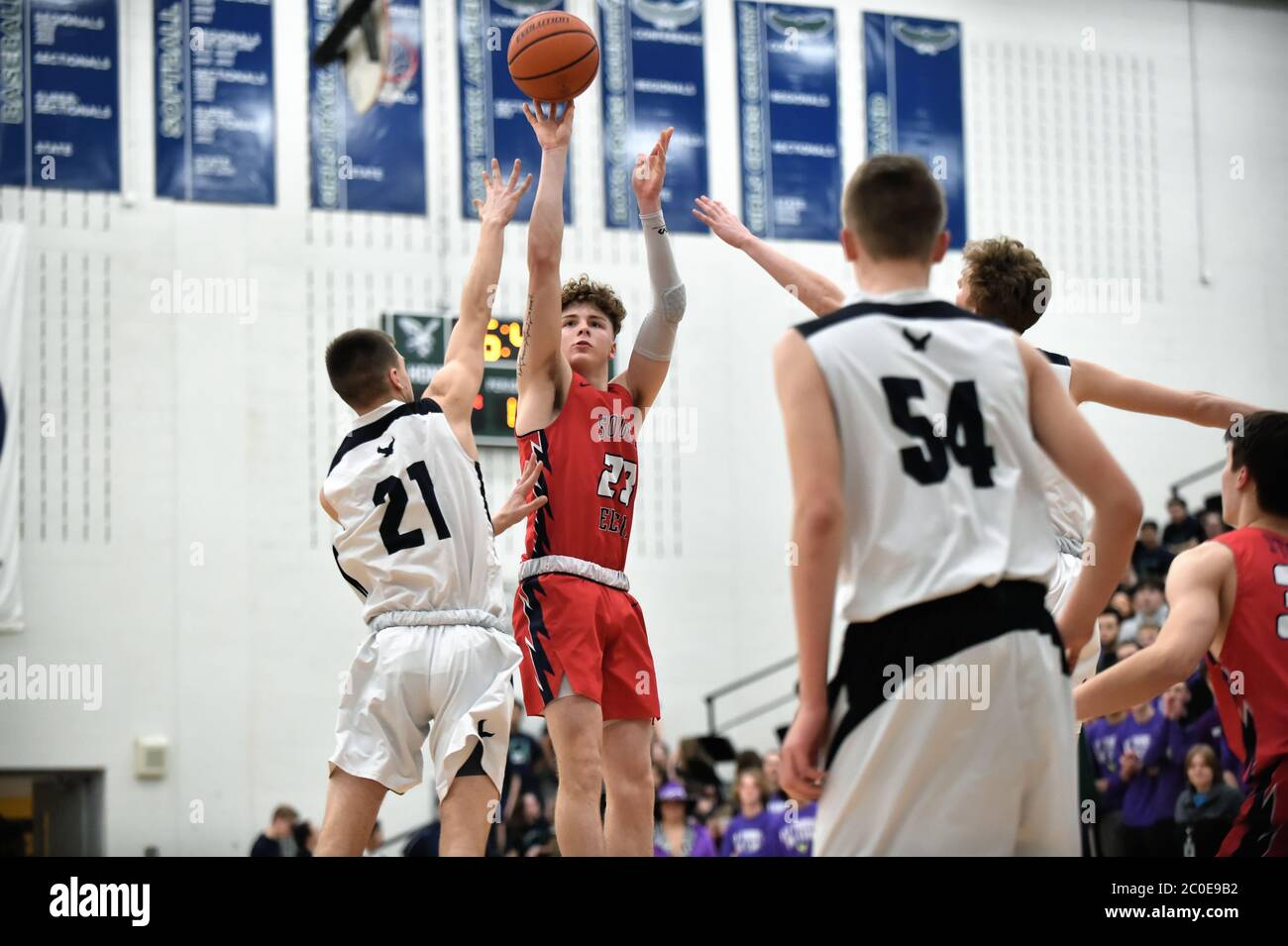 Player releasing a three-point shot from behind the arc over a closing ...