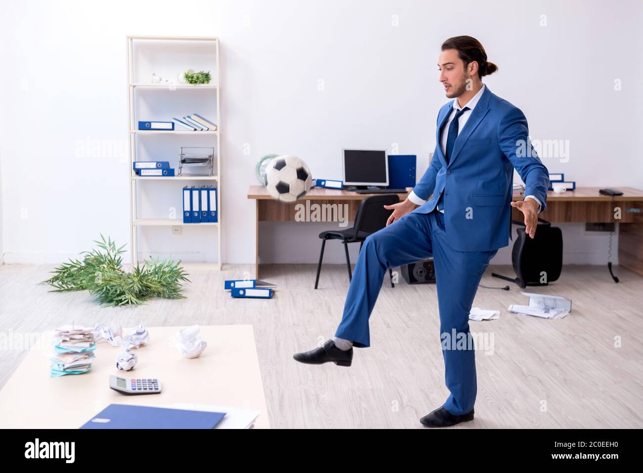 Young employee playing football in the office Stock Photo - Alamy