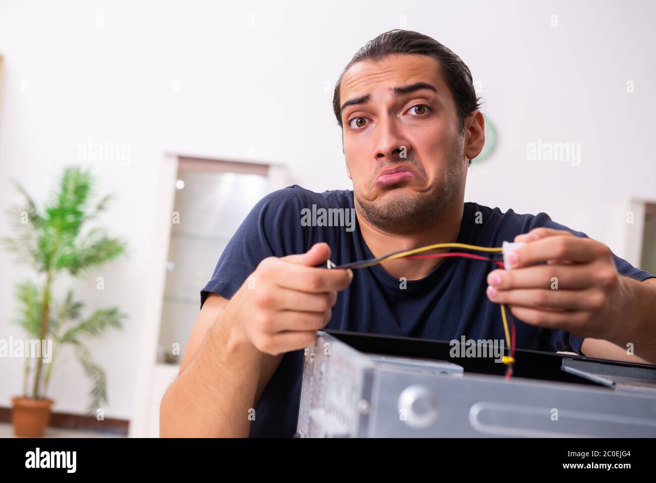 Young man repairing computer at the home Stock Photo - Alamy