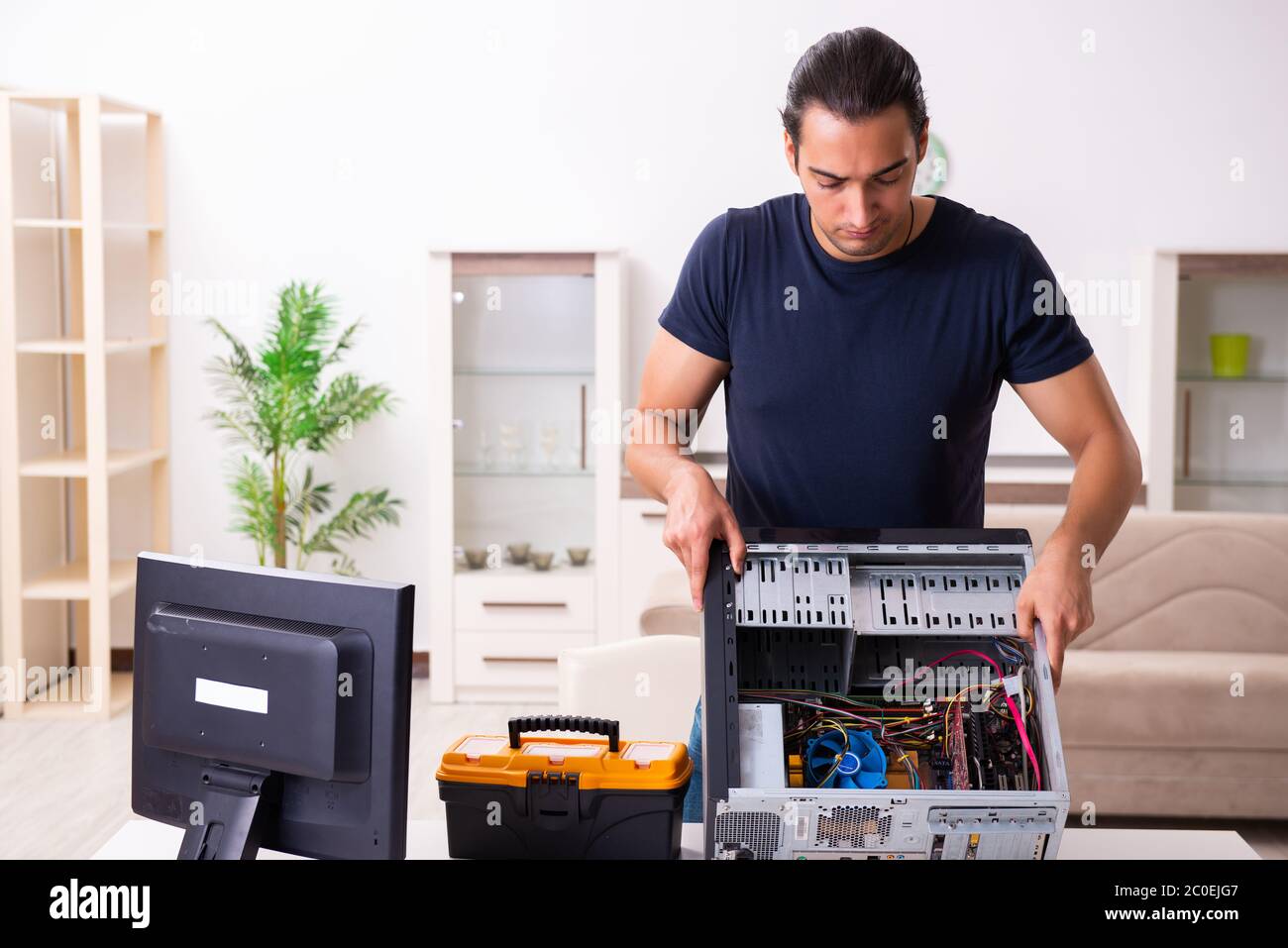 Young man repairing computer at the home Stock Photo - Alamy