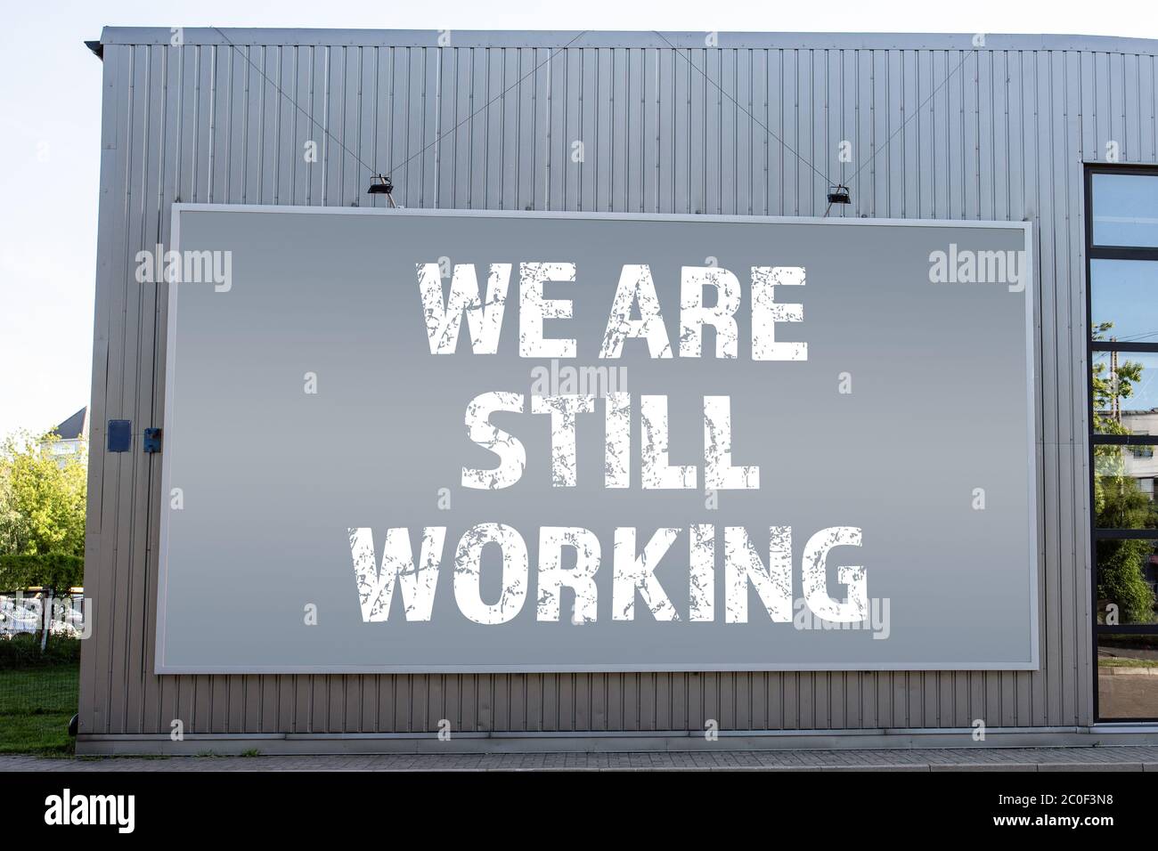 WE ARE STILL WORKING. Advertising and information on the building wall ...