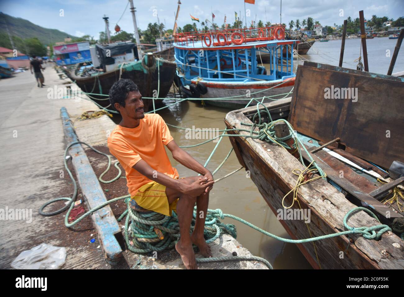 Uran, India. 11th June, 2020. A fisherman sits near his boat parked at ...