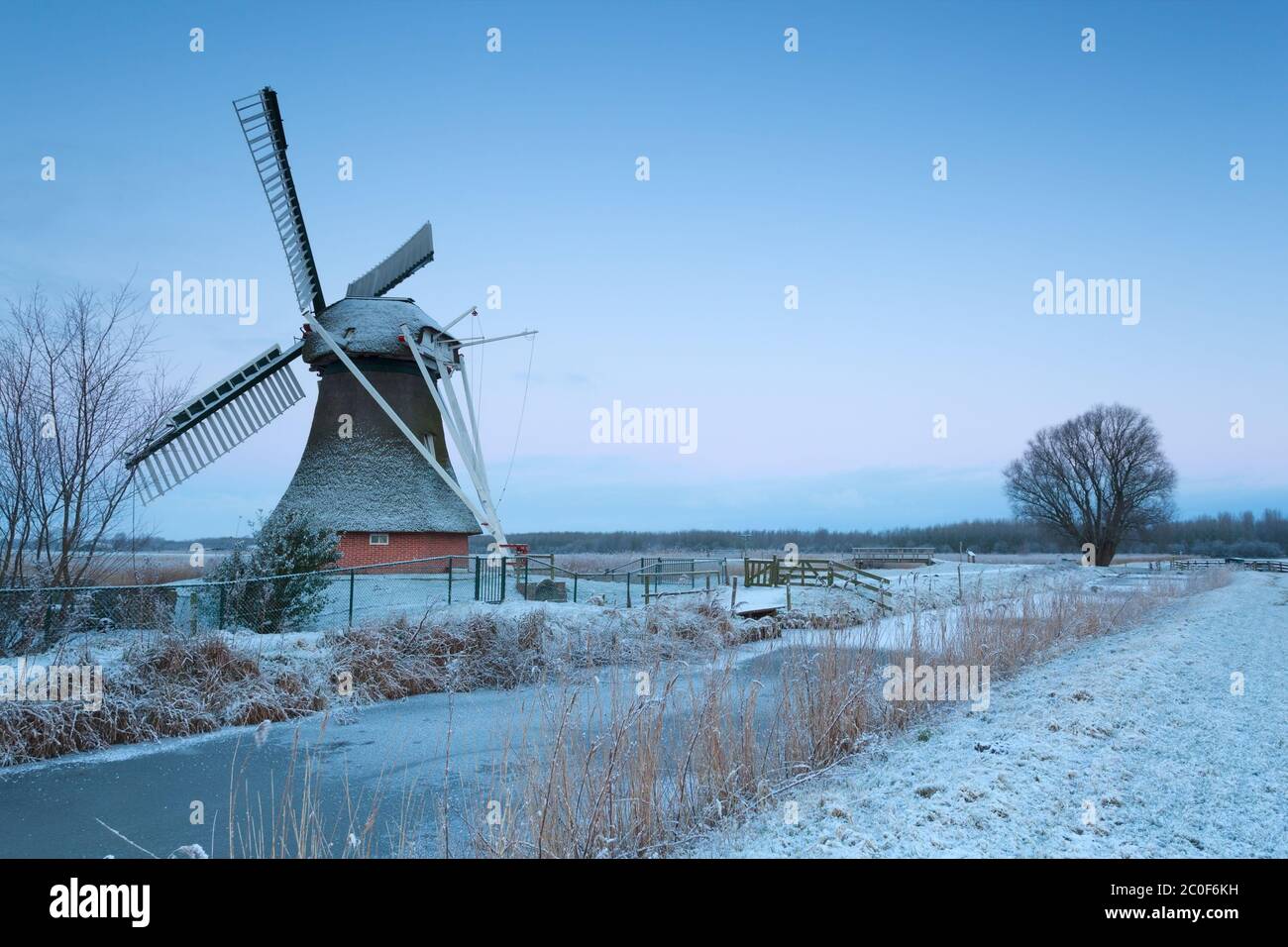 charming windmill in winter at sunrise Stock Photo - Alamy