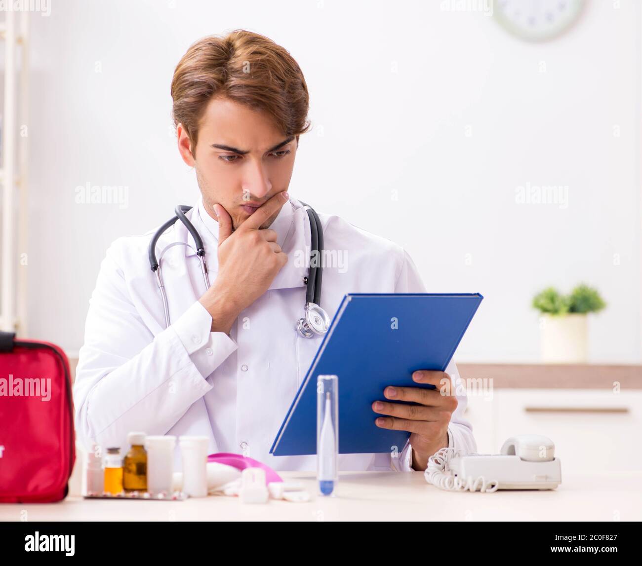 The young doctor with first aid kit in hospital Stock Photo - Alamy
