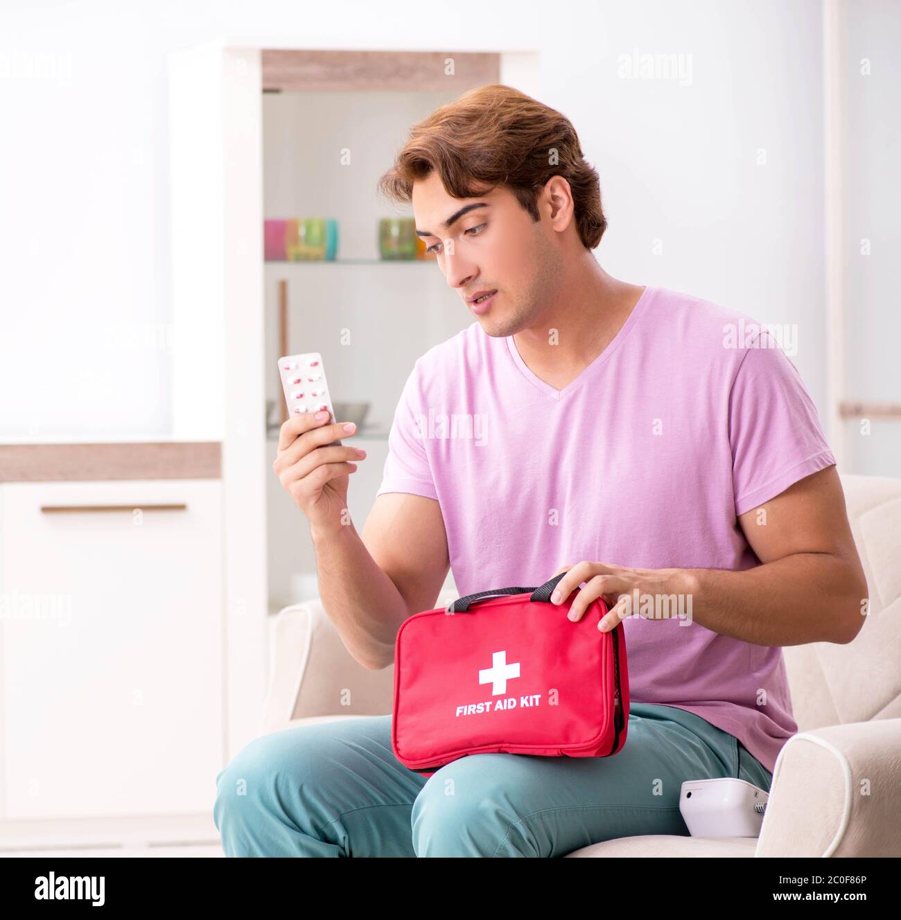The sick man at home with first aid kit Stock Photo - Alamy