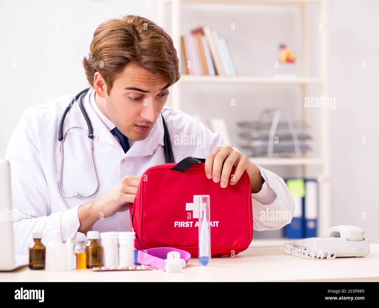 The young doctor with first aid kit in hospital Stock Photo - Alamy