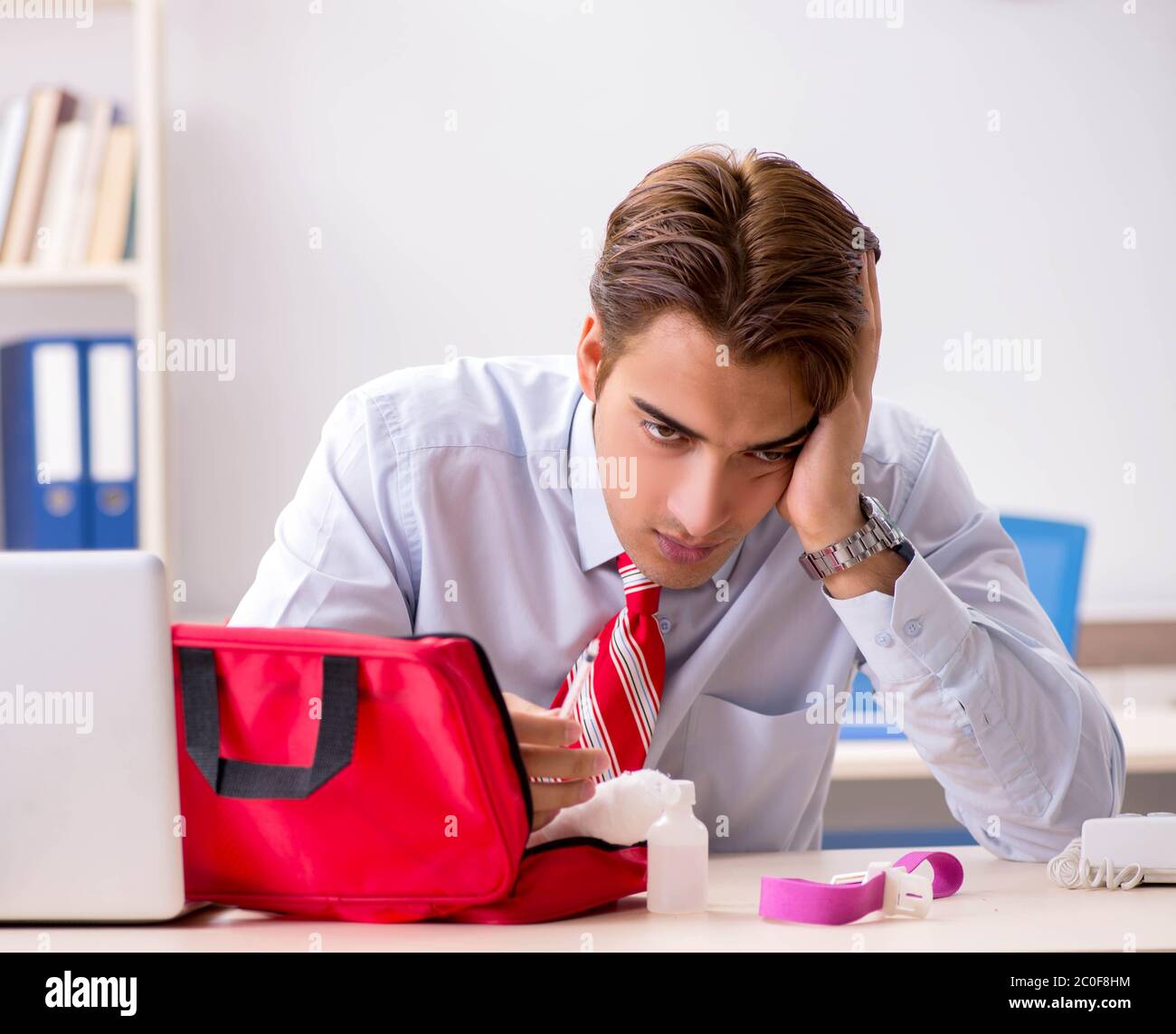 The man with first aid kit in the office Stock Photo - Alamy