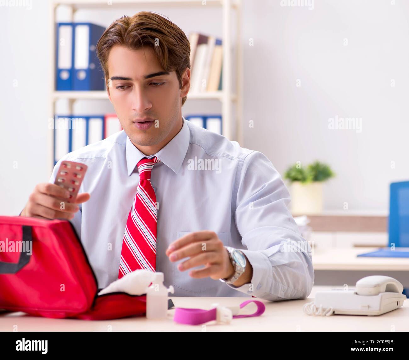 The man with first aid kit in the office Stock Photo - Alamy