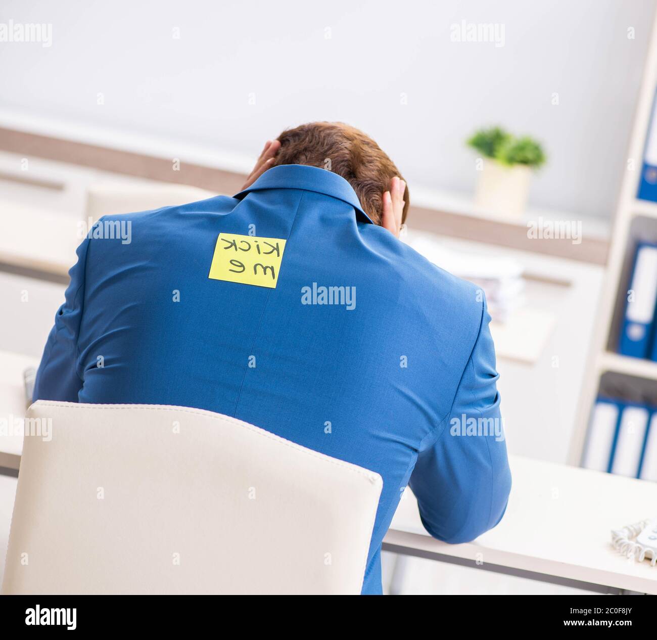 The office prank with kick me message on sticky note Stock Photo - Alamy