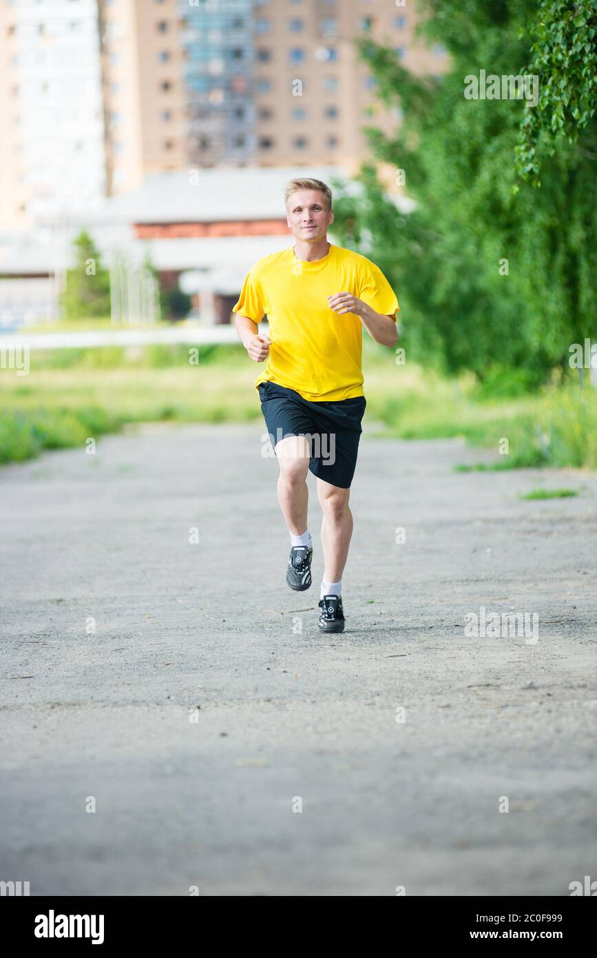 Sporty man jogging in city street park. Outdoor fitness Stock Photo - Alamy