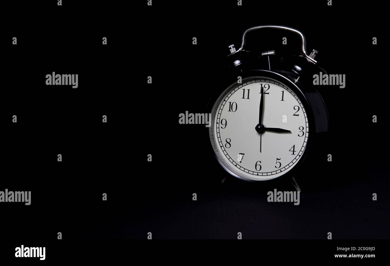 Black retro alarm clock on dark background. Night time Stock Photo - Alamy