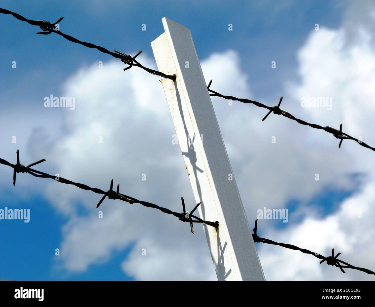 sharp steel barbed wire in low angle view. run through white steel ...