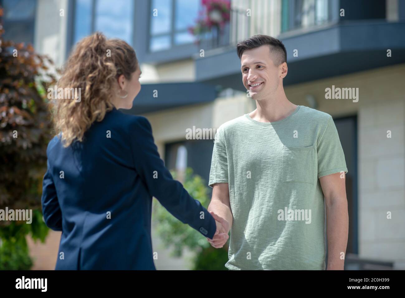 Elegant businesswoman shaking hands with her smiling client Stock Photo ...
