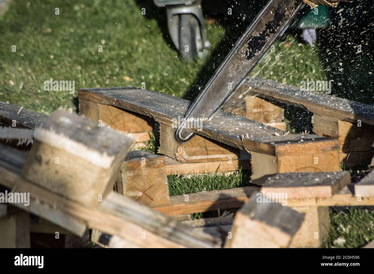 A wooden pallet being cut up with a chainsaw Stock Photo - Alamy