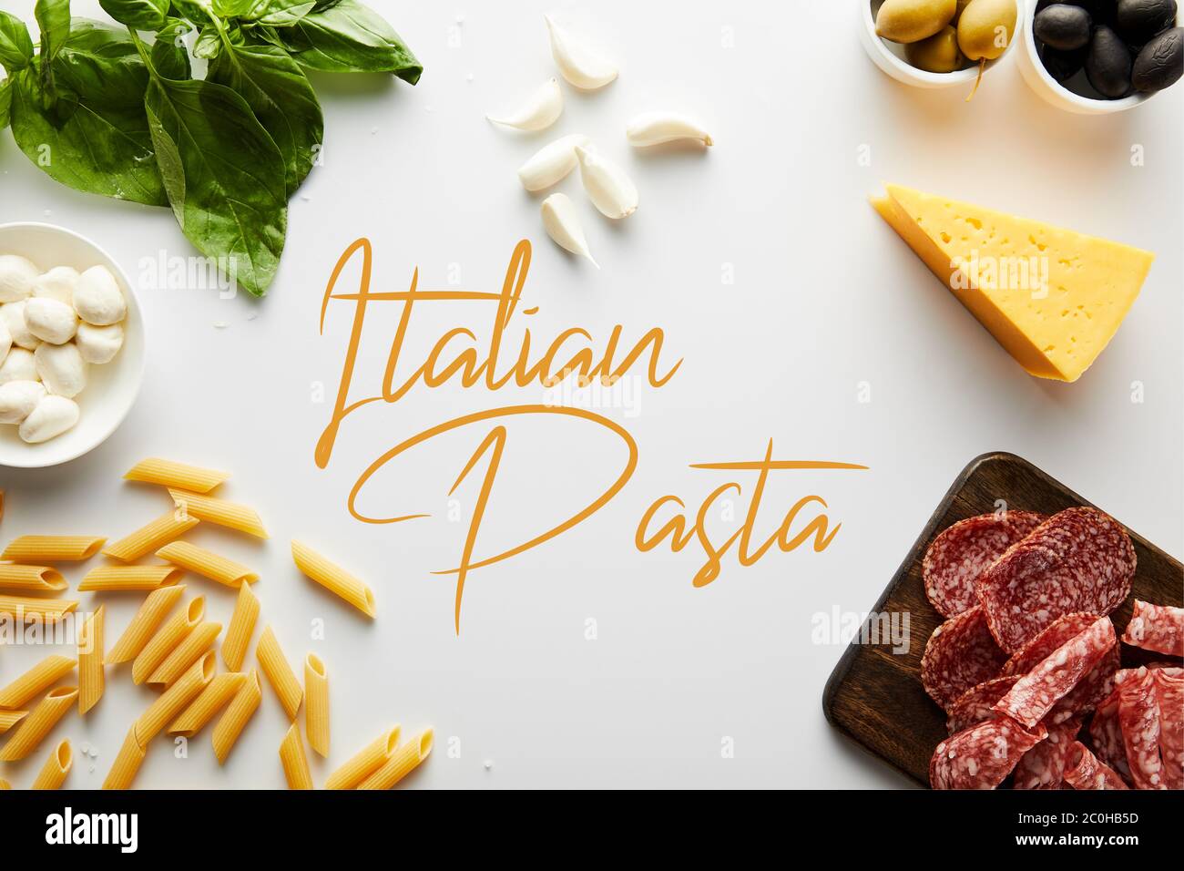 Top view of pasta, meat platter, cheese and ingredients on white ...
