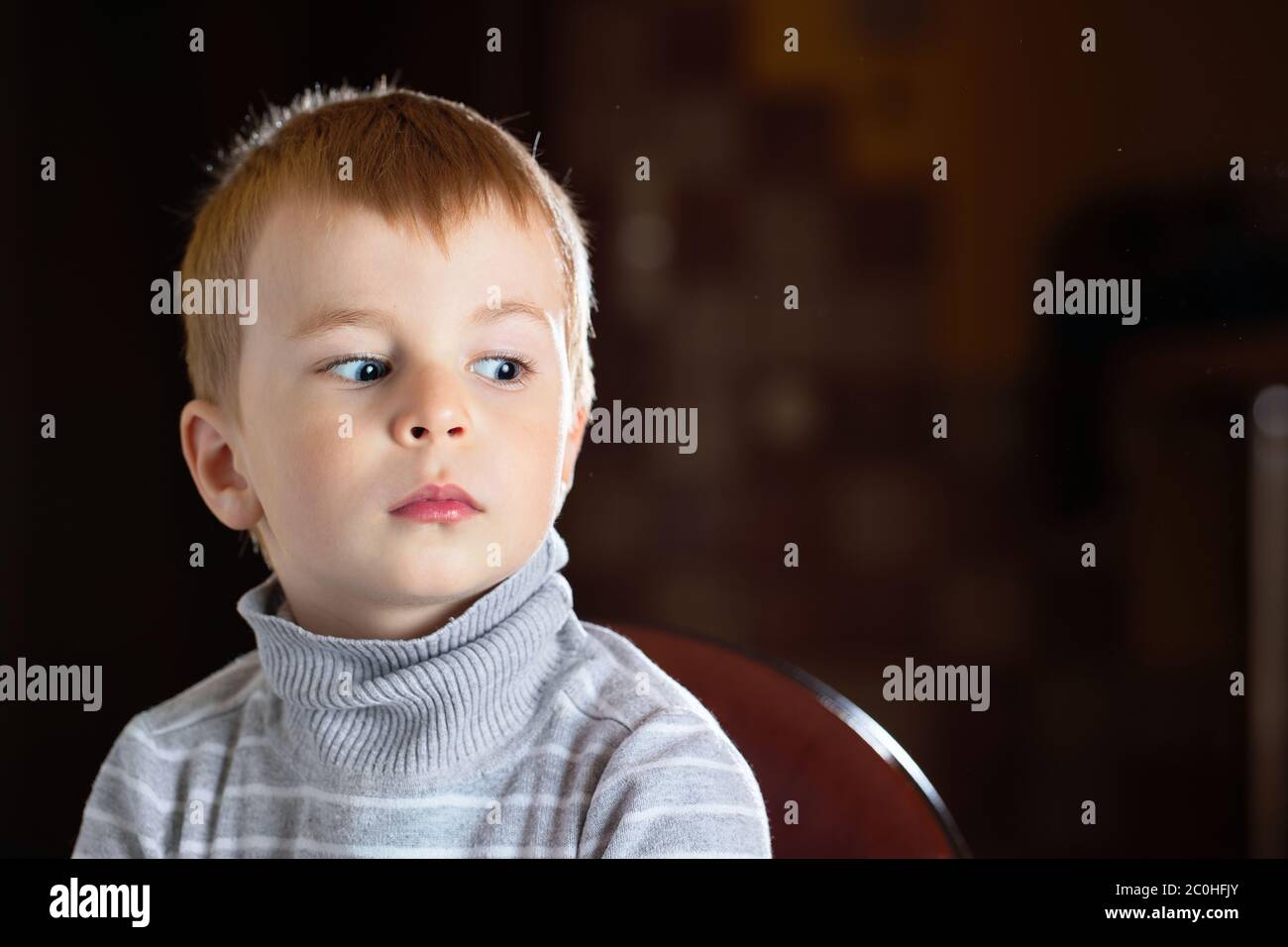 Facial portrait of scared pensive blond boy looking away with fear over ...