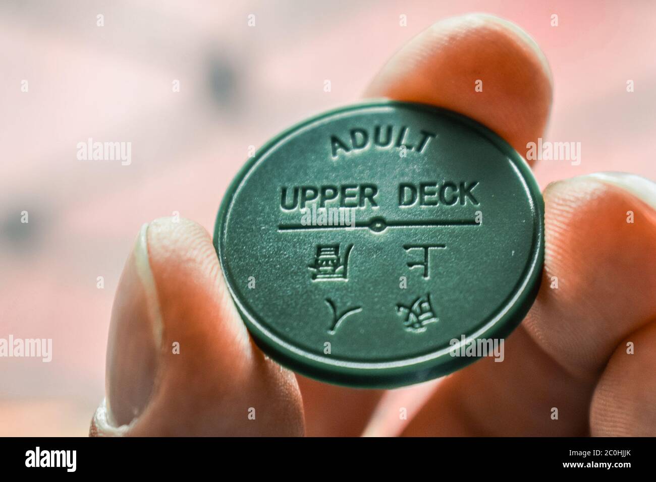 A close up shot of a male hand holding a green token for the Hong Kong ...