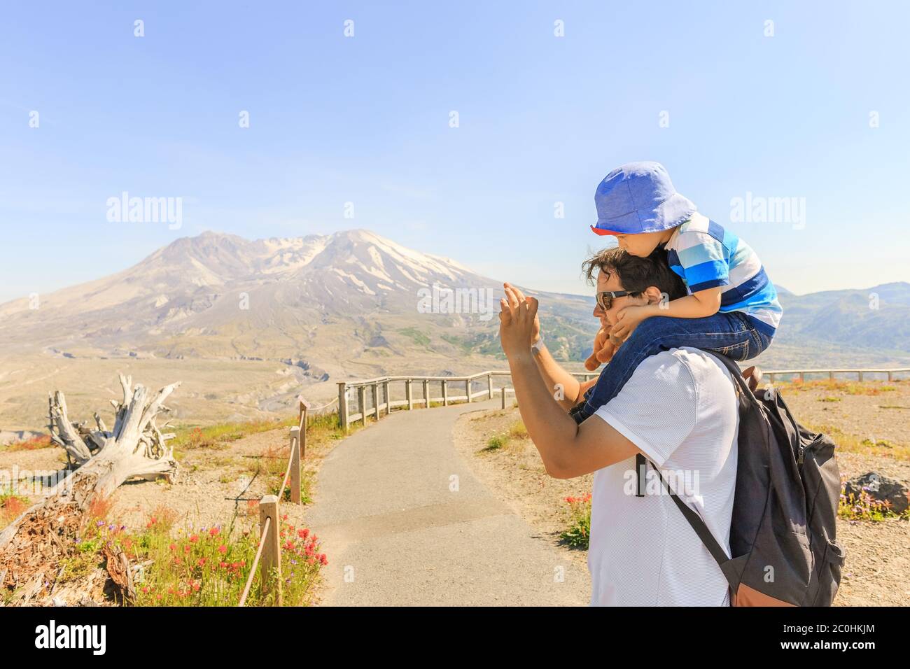 Father is taking pictures on a trace near Mount St. Helens and a little ...