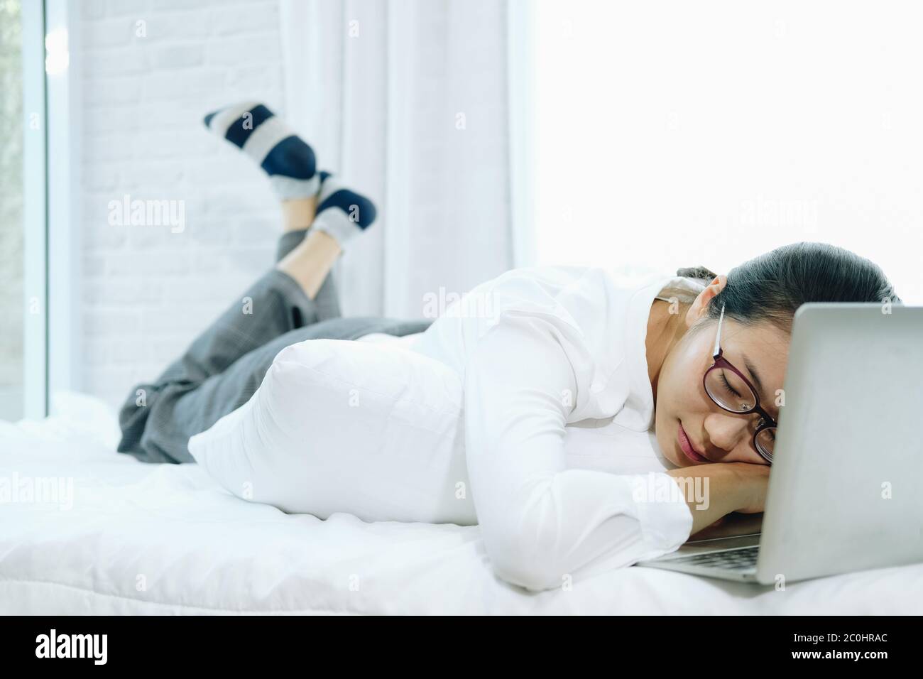 woman sleeping lying resting on bed laying head on computer laptop at ...