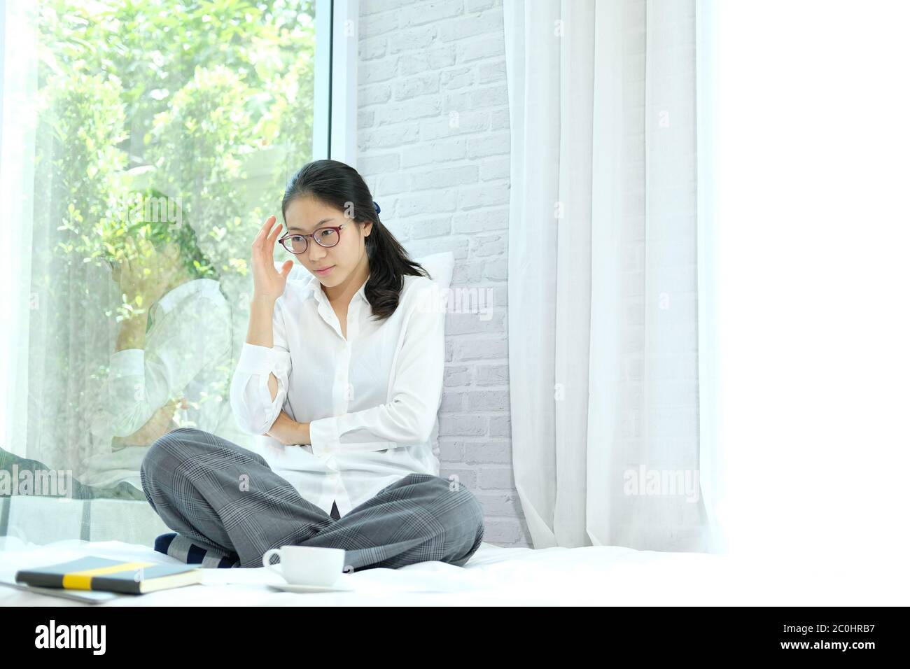 asian woman sitting resting on bed thinking about something at home ...