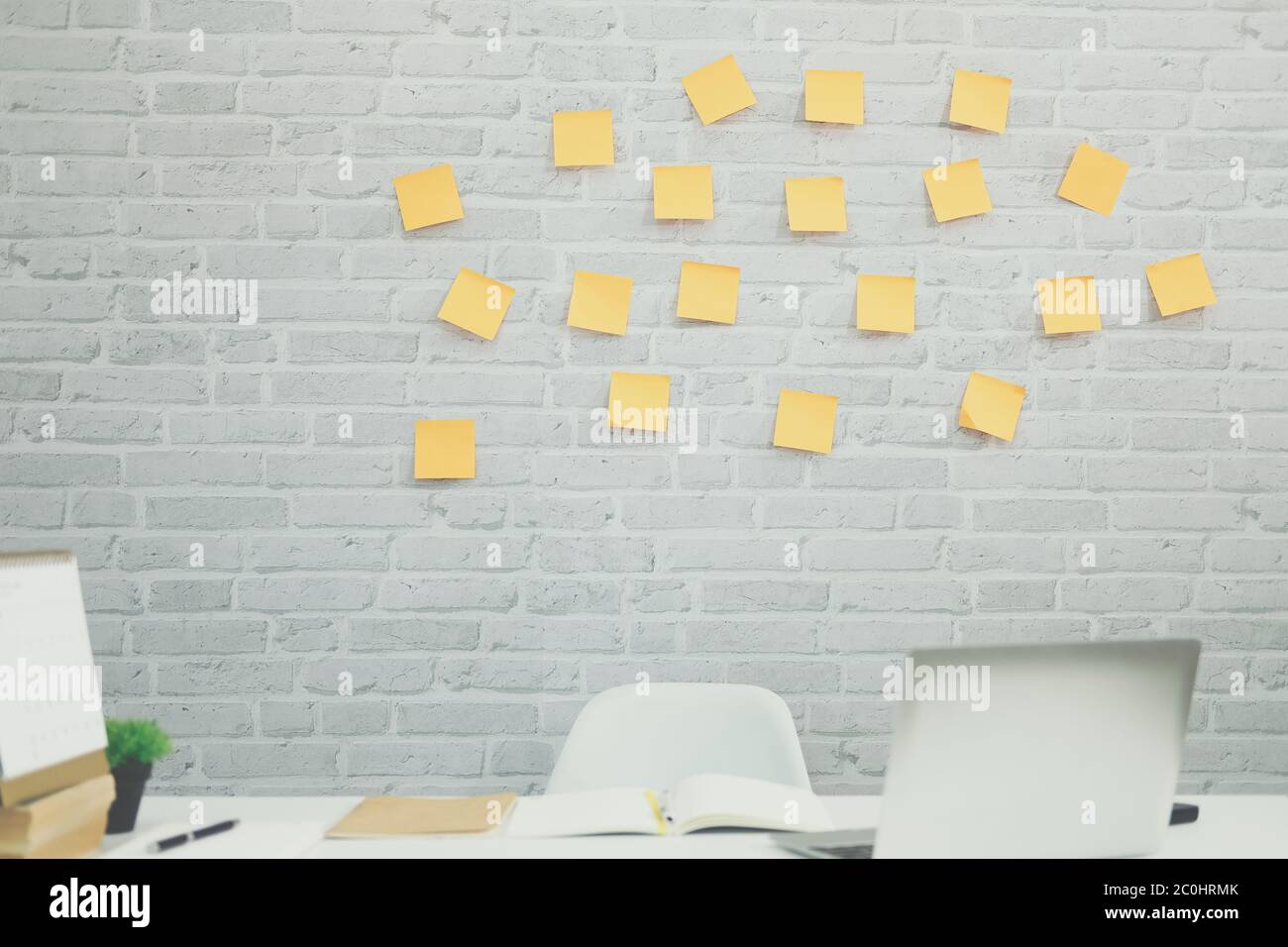 sticky adhesive note on white office wall. desk at workplace interior ...
