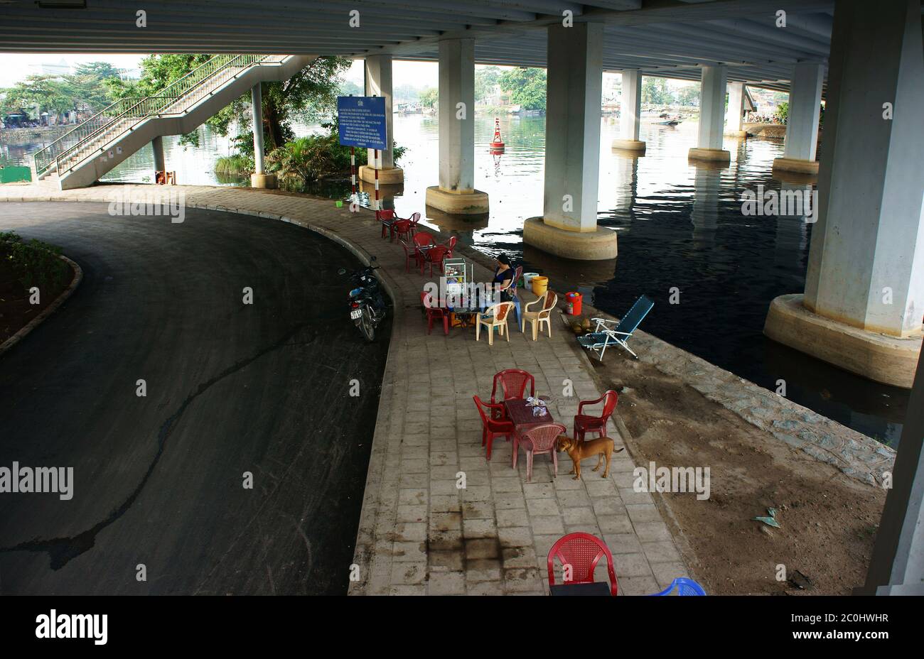 Vietnamese woman sit on plastic table, chair at outdoor coffee shop on ...